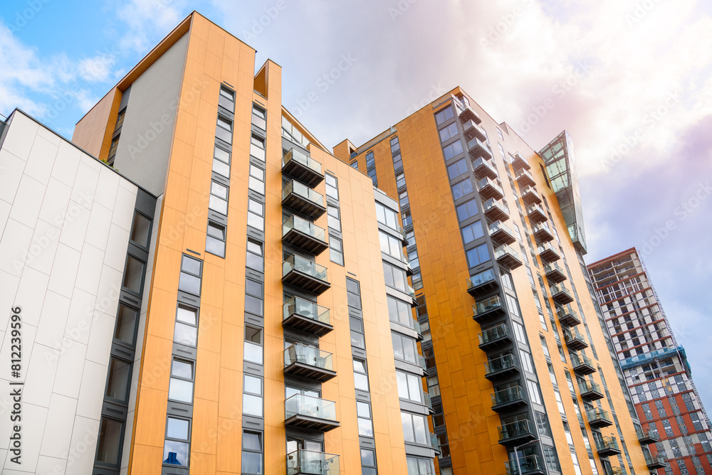 Modern high rise blocks of flats under partly cloudy sky in summer. A ...