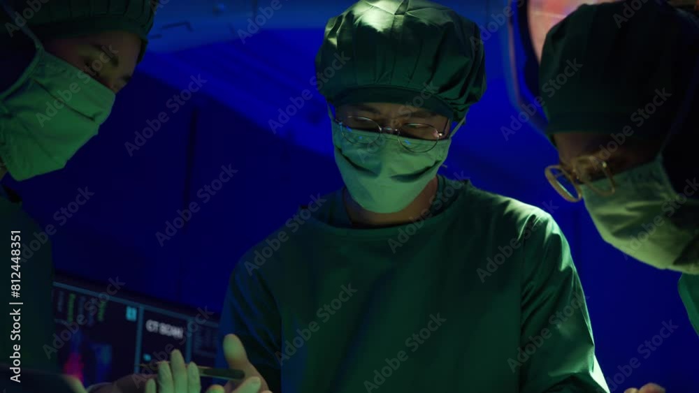 An intense scene in an operating room where a surgical team is ...