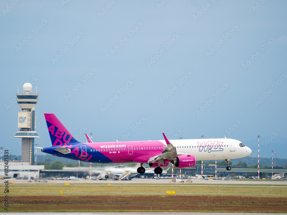 Wizzair Airbus A321 is landing at MXP Milano Malpensa international airport. Abu Dhabi livery ...