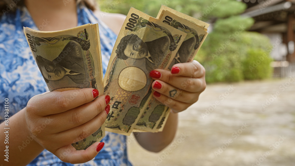 Caucasian young woman's hands counting wealth of japan yen banknotes at ...