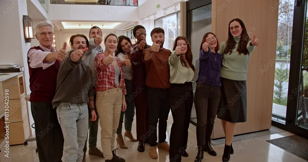 In an office environment, a multi-generational group of smiling ...