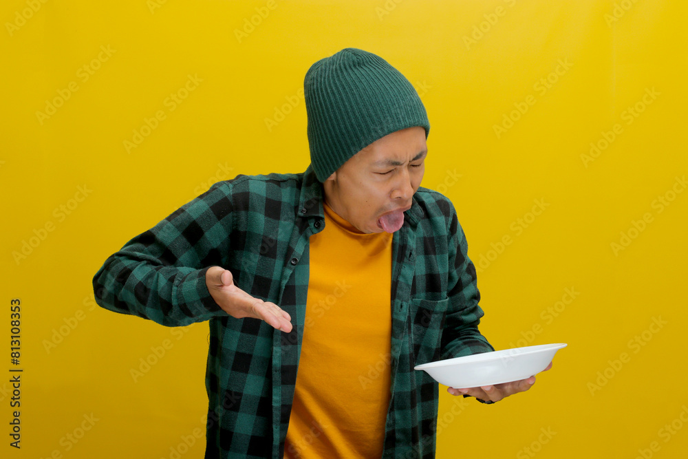 Distressed young Asian man, clutching his stomach and an empty white ...