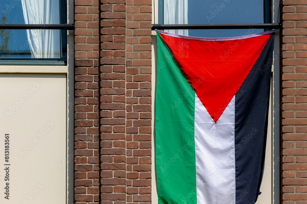 The flag of Palestine hanging outside the window of building, Tricolor ...