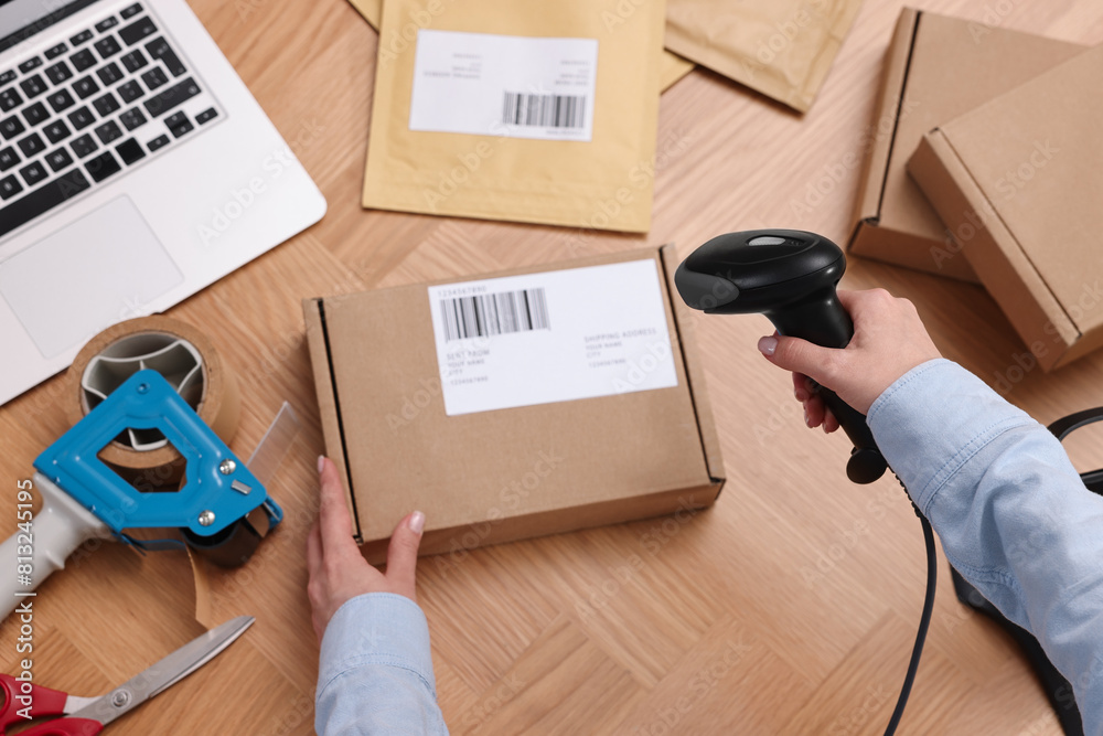 Parcel packing. Post office worker with scanner reading barcode at ...