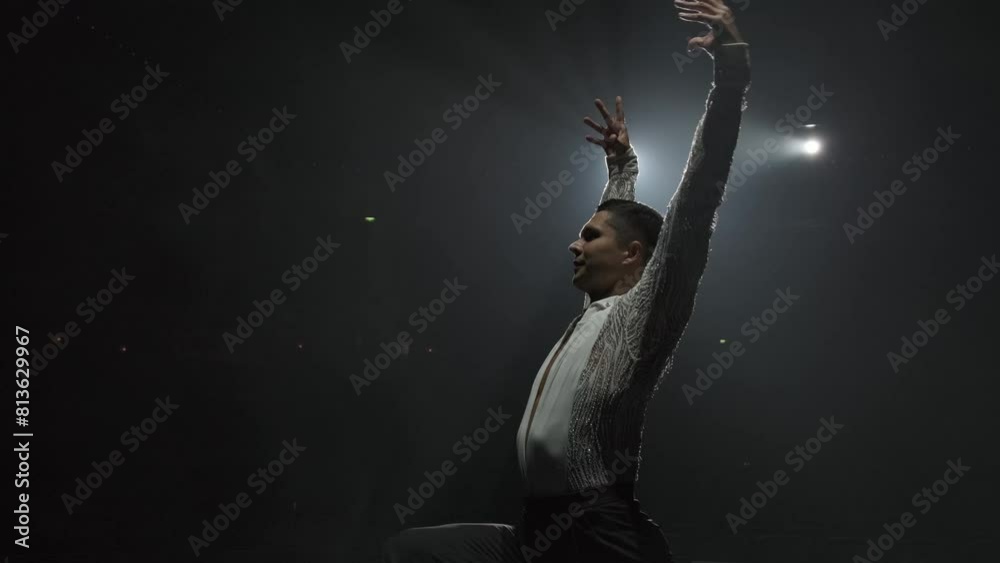 Dancer performs Broken Spanish Turn in ray of light, bending at small ...