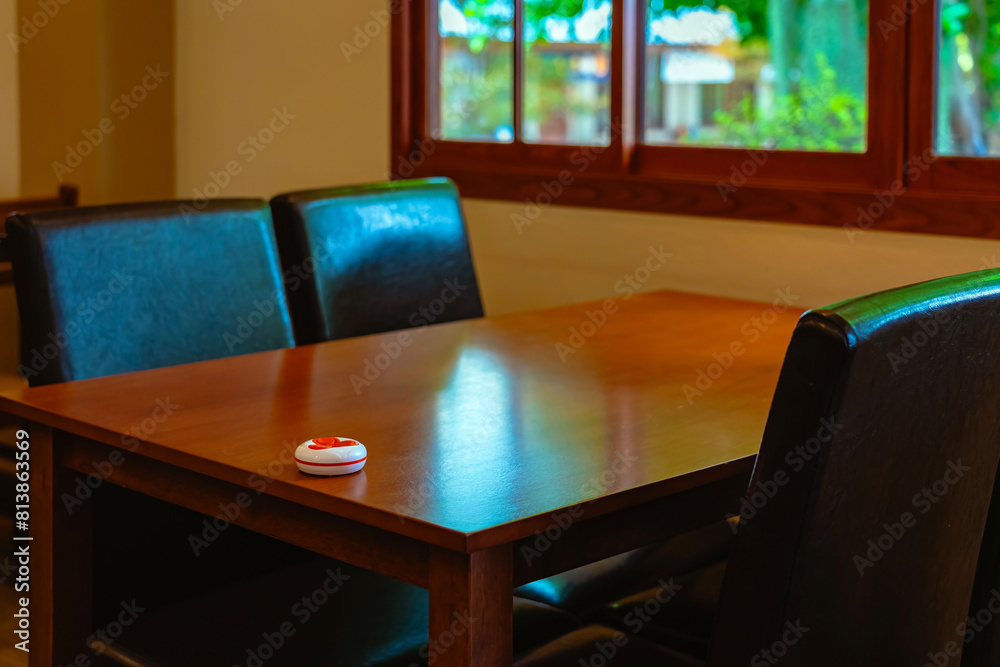 Pager device for ordering food on wooden table in restaurant. Wireless ...