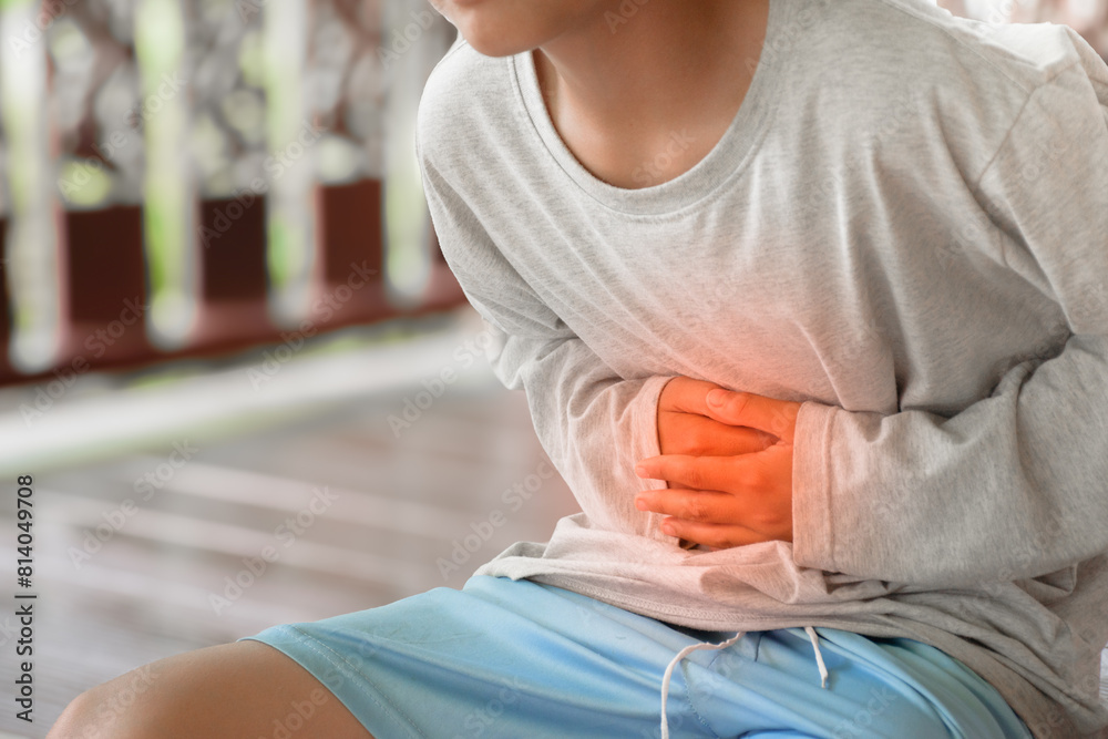 Man is sitting and holding his stomach due to stomach pain or ...