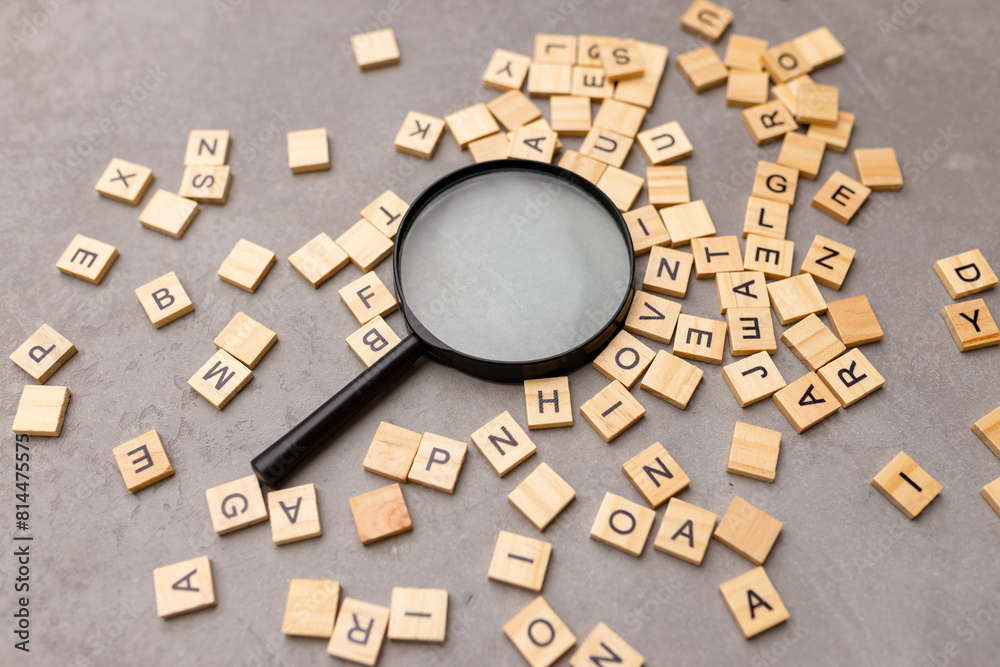 Magnifying glass with many wood letters of English alphabets, learning ...