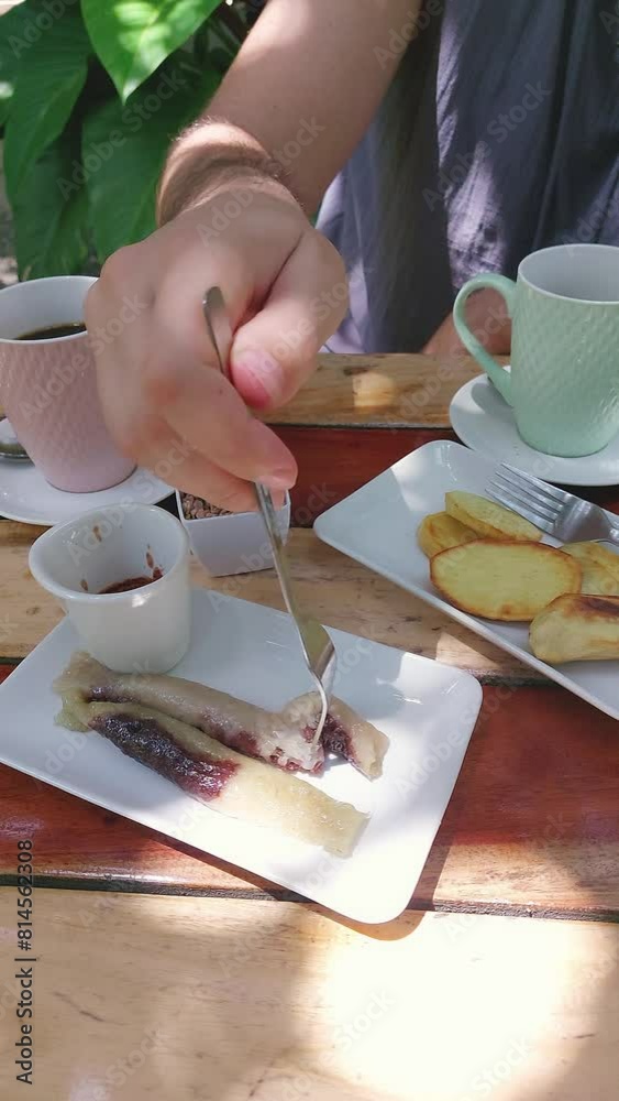 Vertical view of a candid summer afternoon moment of eating suman ...