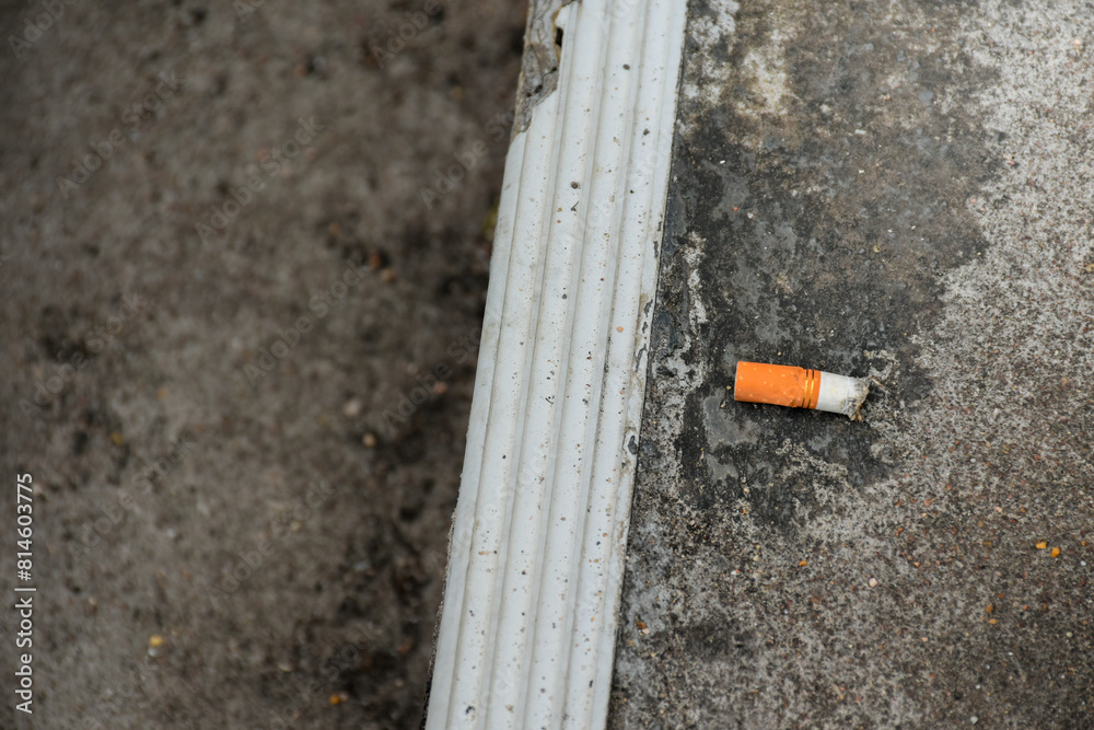 Smoked cigarette butts that are improperly discarded on public concrete ...