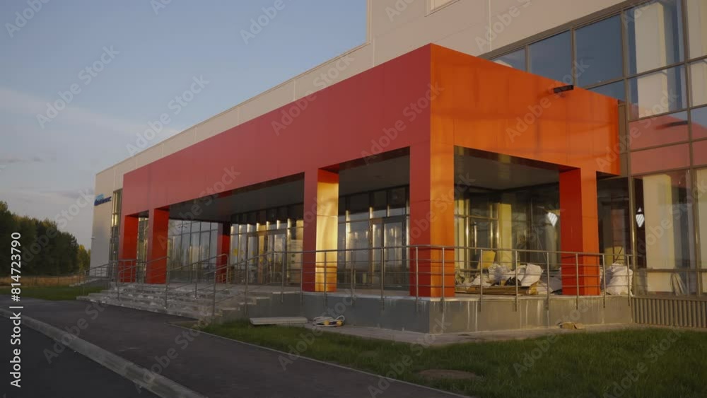 Red entrance with columns and glass doors at shopping center. Modern ...