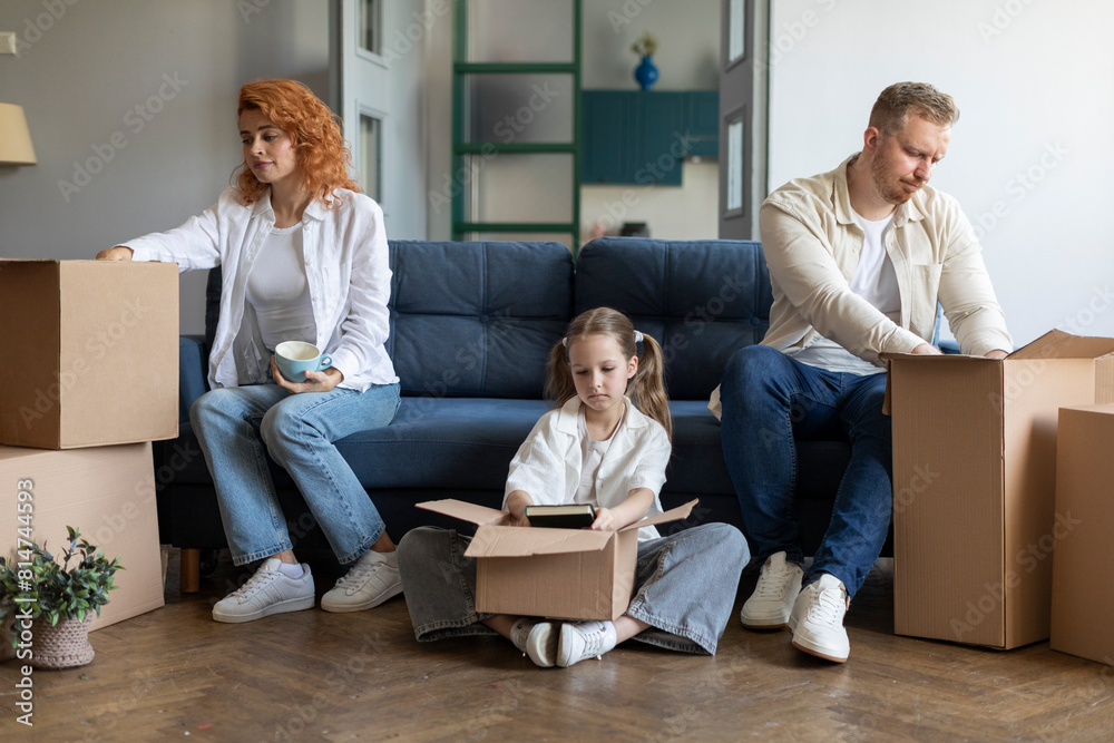 Upset daughter helping mom and dad packing belongings in cardboard ...