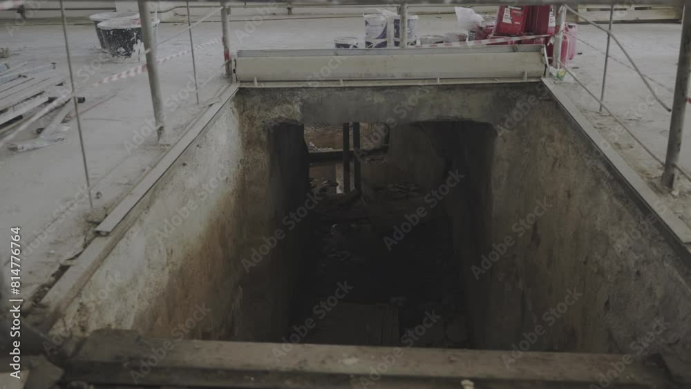 Pit with caution stripe in concrete floor of industrial plant ...
