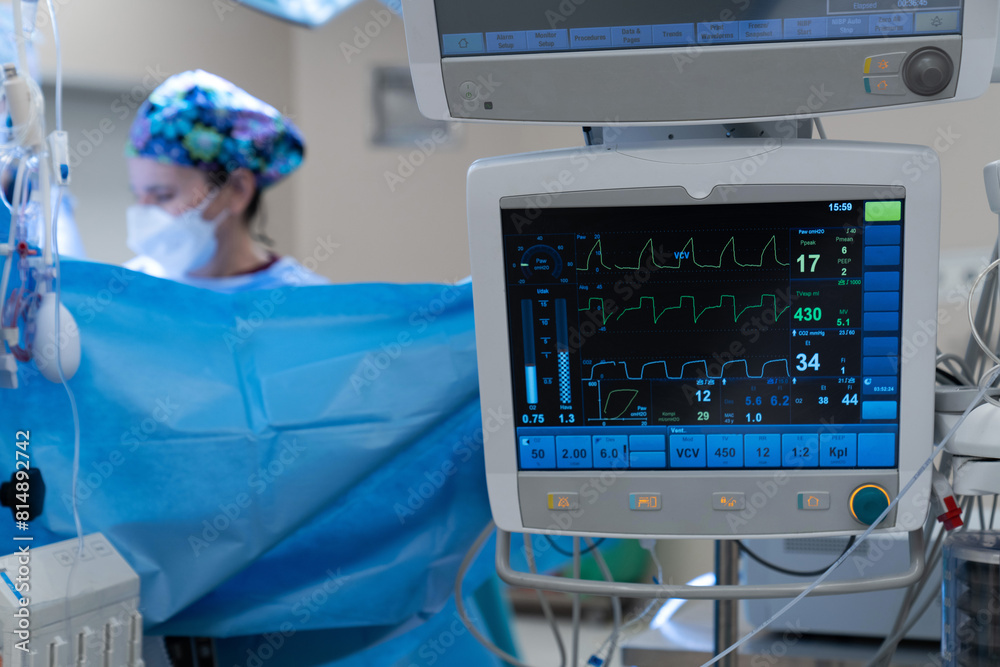 Monitor screen with vital sign and ECG data of patient during surgery ...