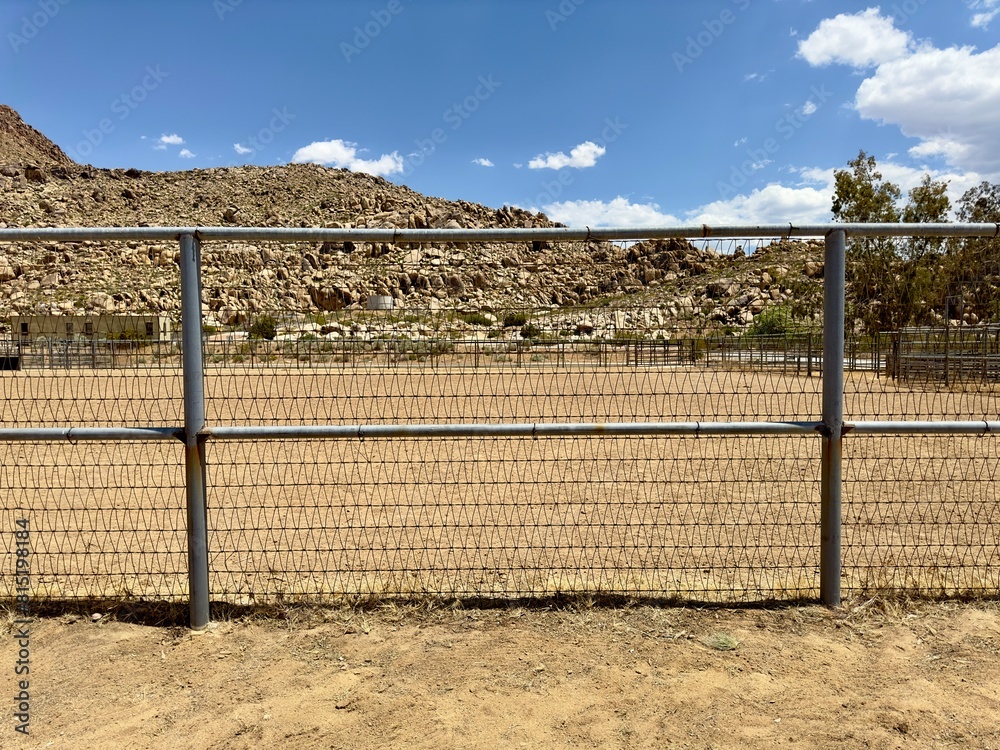 Wild West horse stable corral features rugged wood fencing, dusty ...