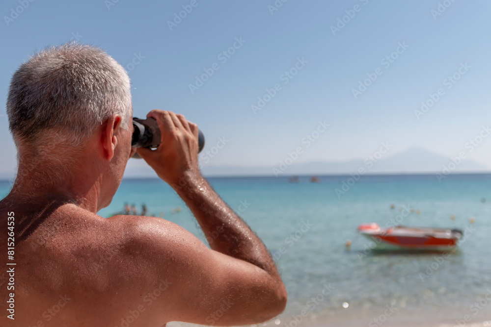 The lifeguard looks through binoculars and keeps people safe in the ...