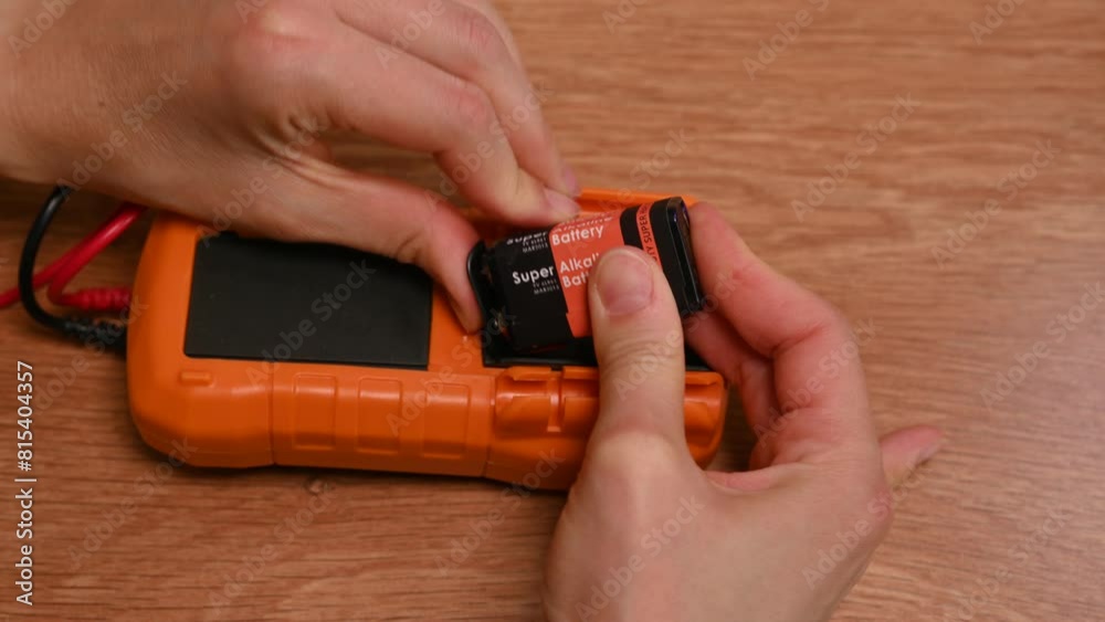 Woman inserts Nine-volt battery into electrical appliance. Close up ...