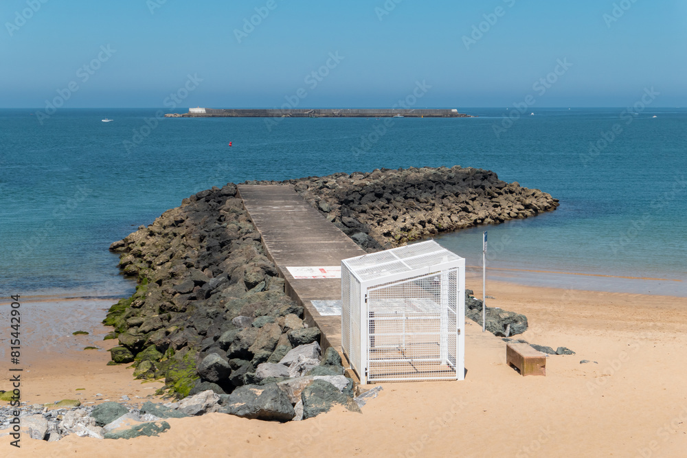 Paredão de rochas na praia de Saint Jean de Luz, com o forte de Socoa em Ciboure ao fundo no ...