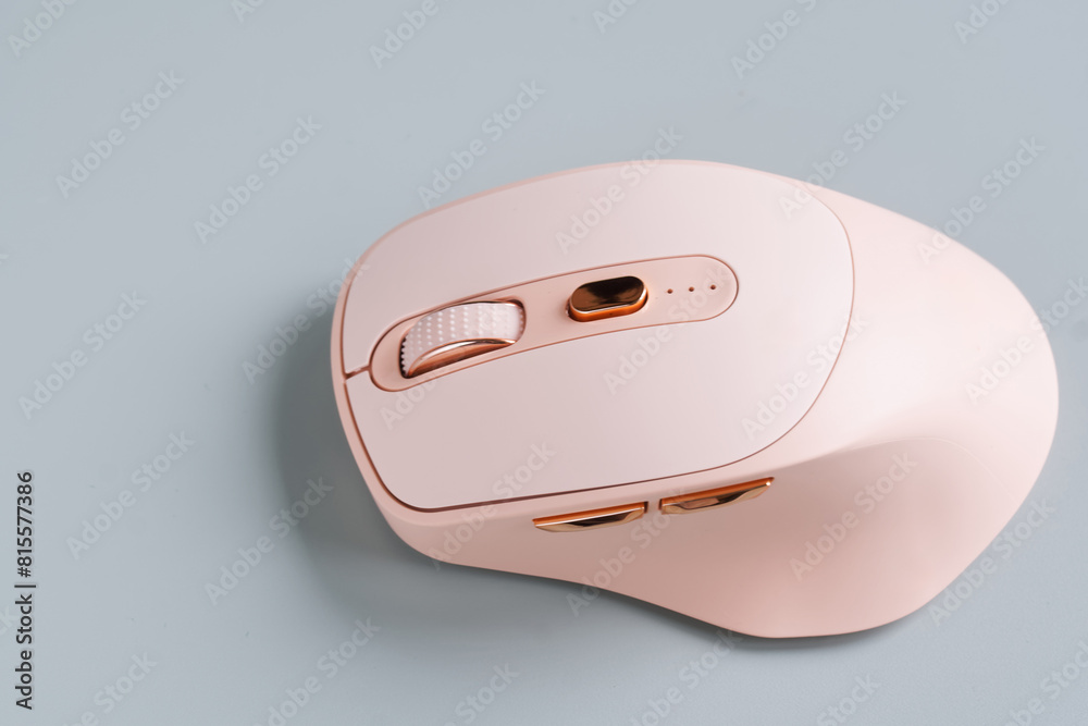 Unusual pink computer mouse with golden buttons on a light pastel ...