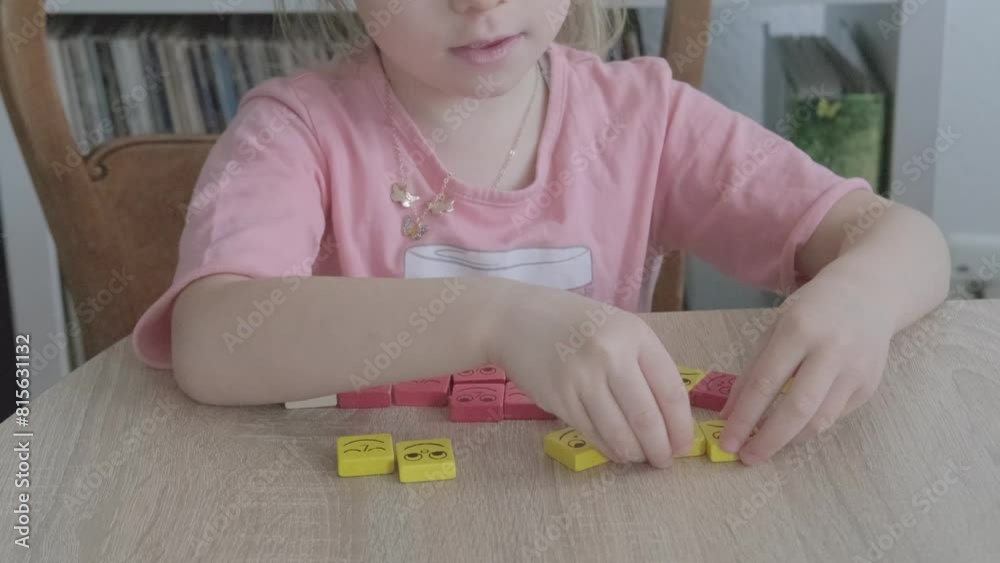 close-up child preschooler using wooden blocks depicting happy and sad ...