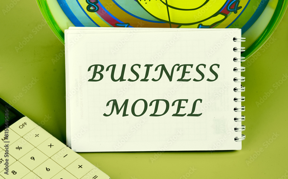 BUSINESS MODEL text on a notepad on the background of a clock next to a ...