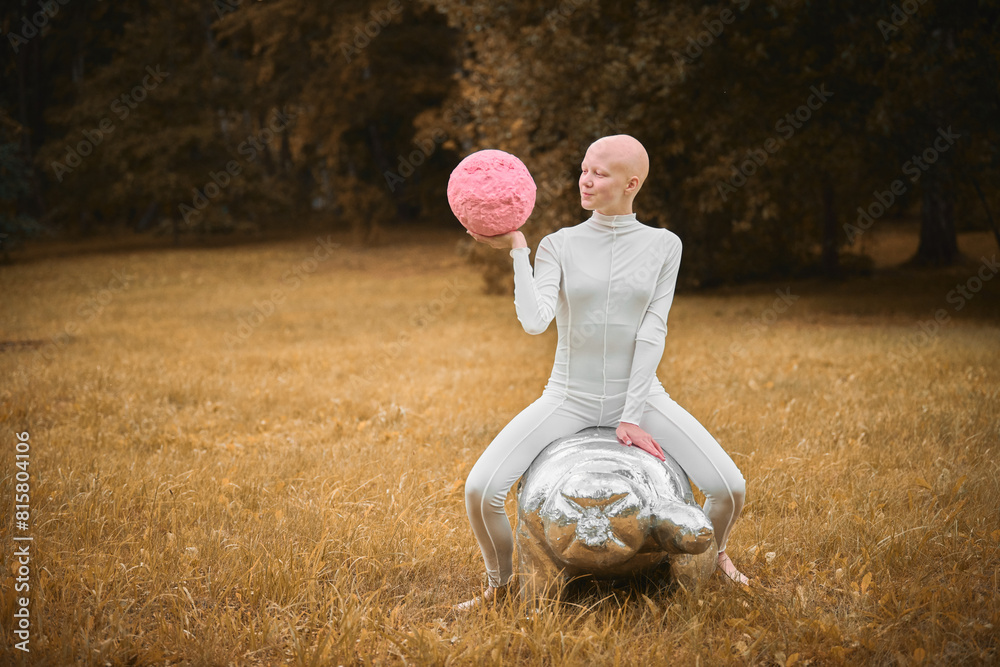Young hairless girl with alopecia in white cloth sits on tardigrade ...