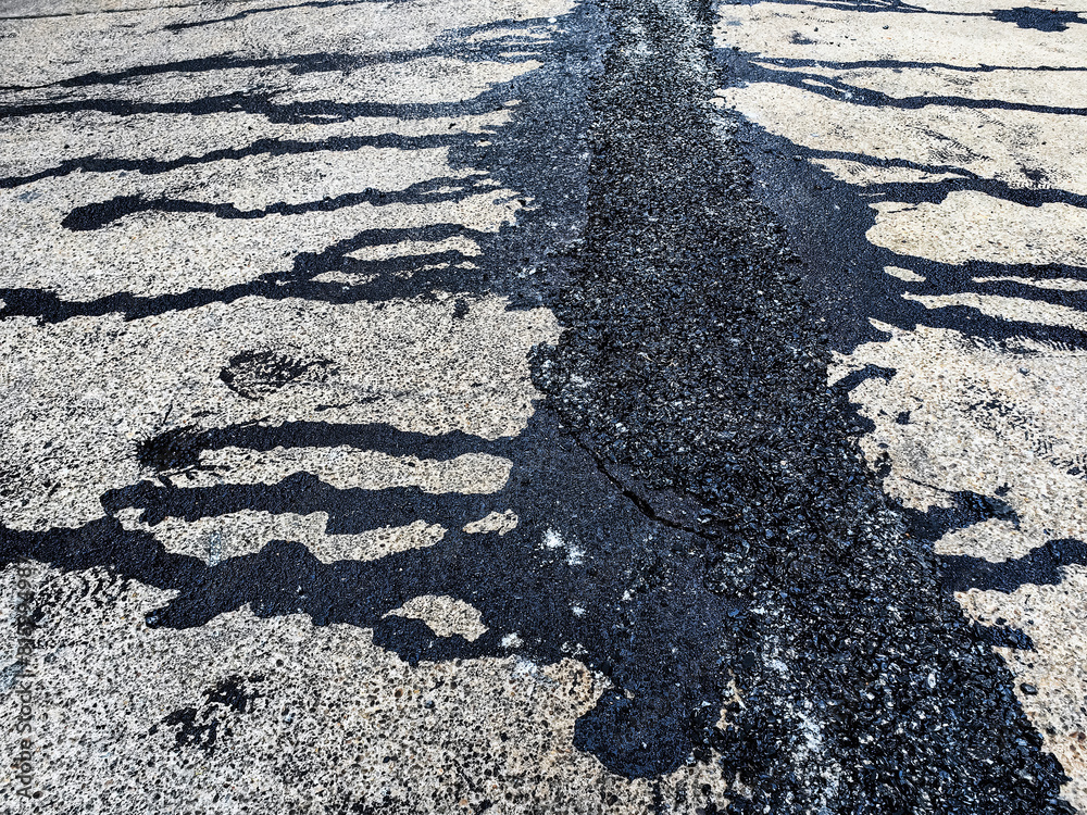 Asphalt on road. Street with black tar filling the cracks. Cracks in ...