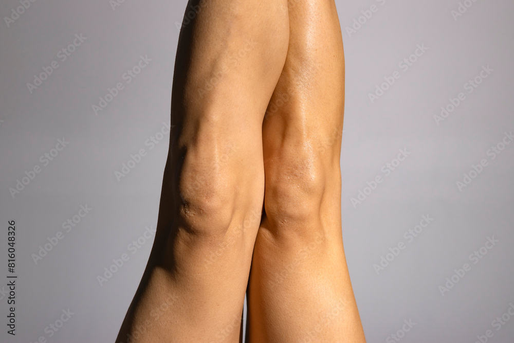 Female knees pose on gray background. This composition exudes elegance ...