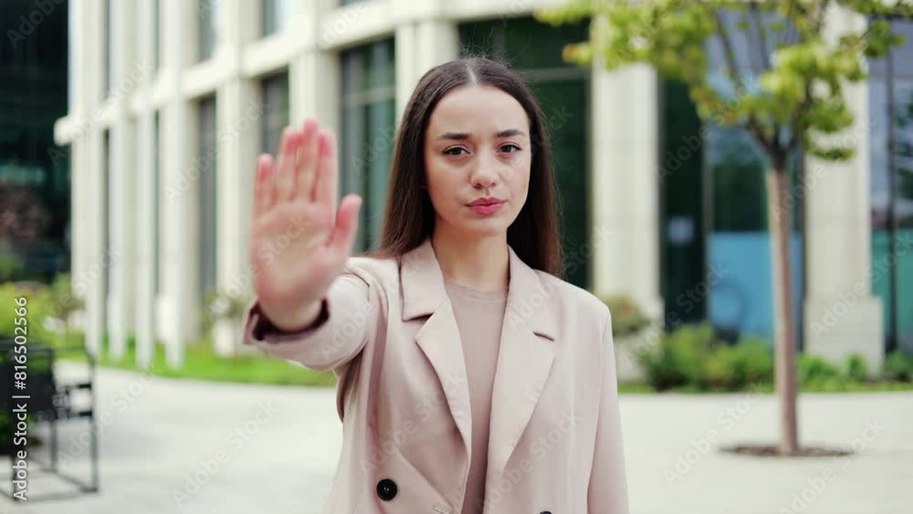 Skeptical woman extending hand to camera in negative gesture and saying ...