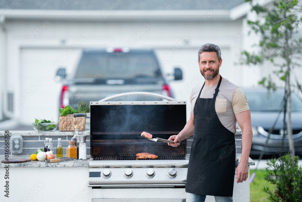 Male chef grilling and barbequing in garden. Barbecue outdoor garden ...