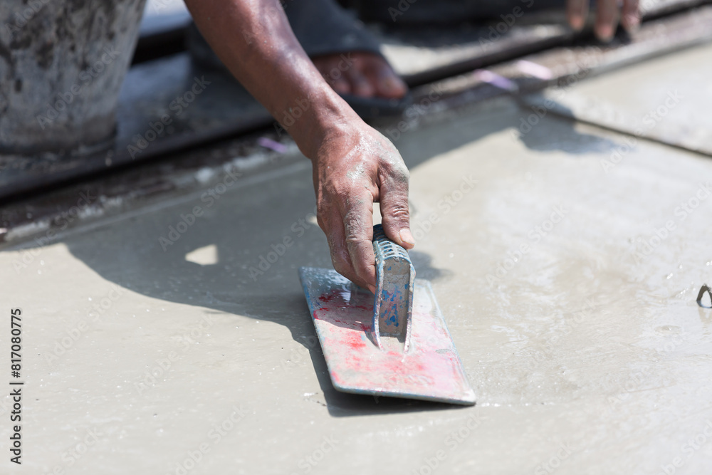 Construction worker plastering wet concrete at precast concrete wall ...
