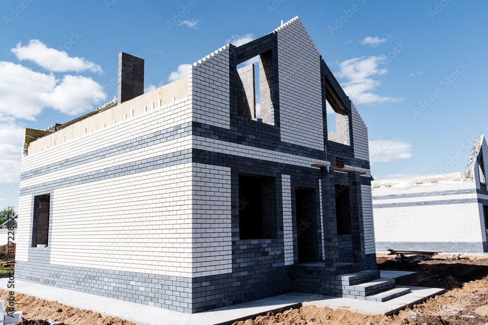 A modern brick house is under construction, showcasing innovative ...