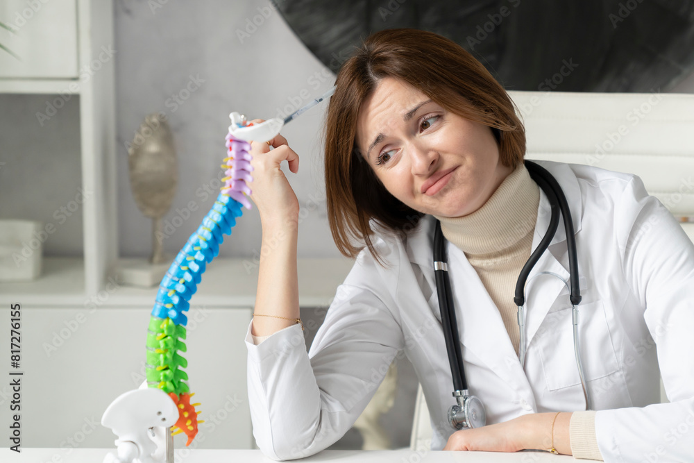 Young attractive female doctor orthopedist demonstrating the problem on ...