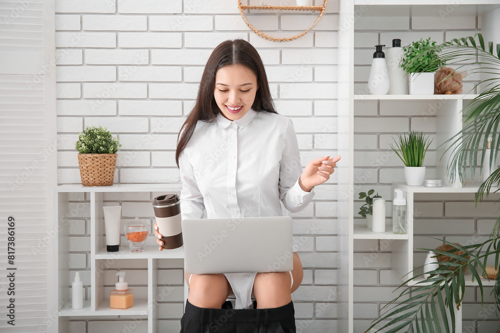 Young Asian businesswoman using laptop on toilet bowl in restroom Stock ...