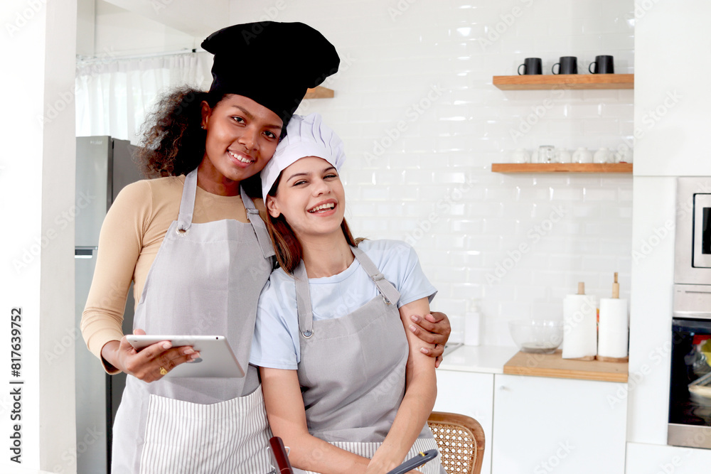 Happy homosexual lesbian LGBT couple with apron and chef hat cooking ...