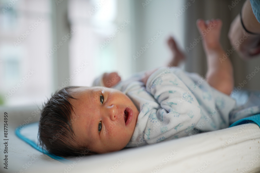 Newborn baby on changing table, wide-eyed and alert, during a diaper ...