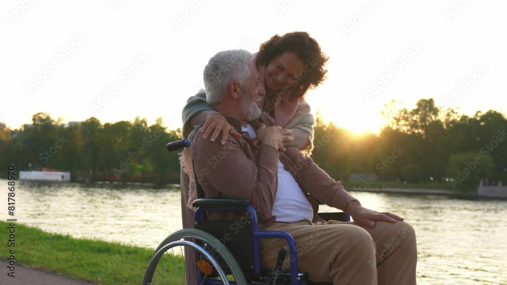 Old man in wheelchair walking with caregiver senior woman on road in ...