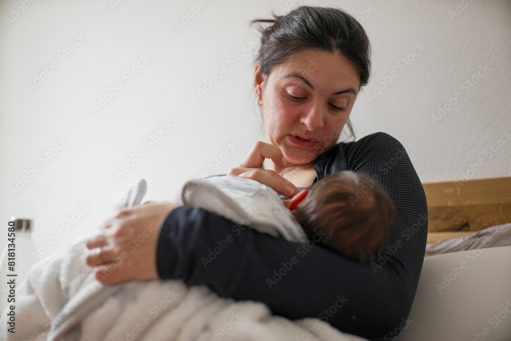 Mother nursing her newborn, eyes closed, showing the emotional and ...