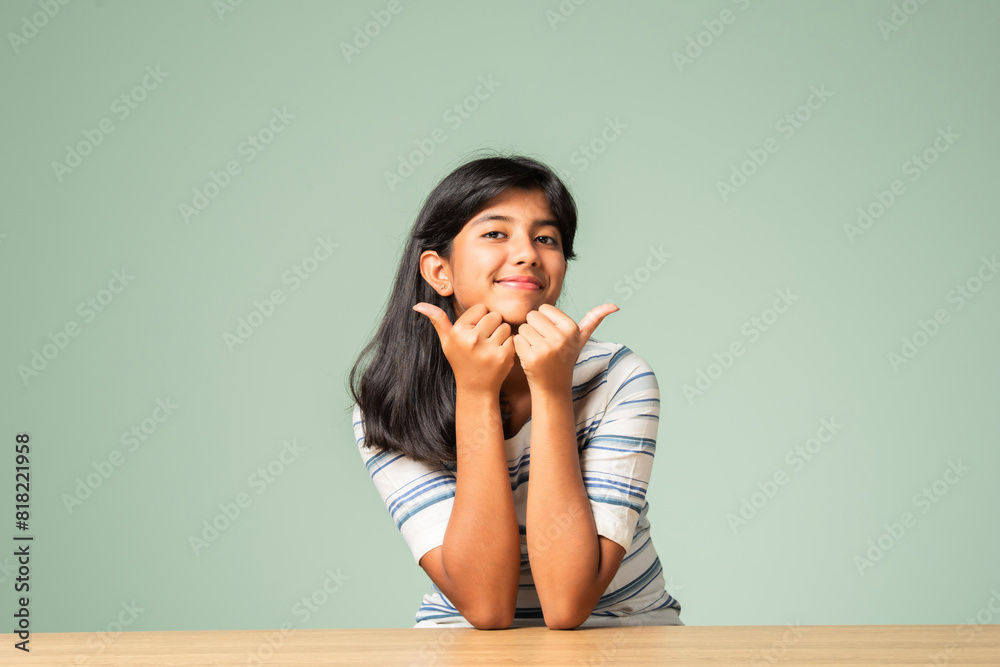 Happy Indian asian teenage girl showing or pointing something sitting ...