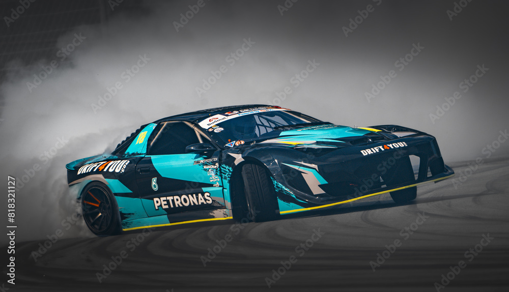 Riga 28-04-2024 Drift A blue racecar speeds around the track, emitting ...