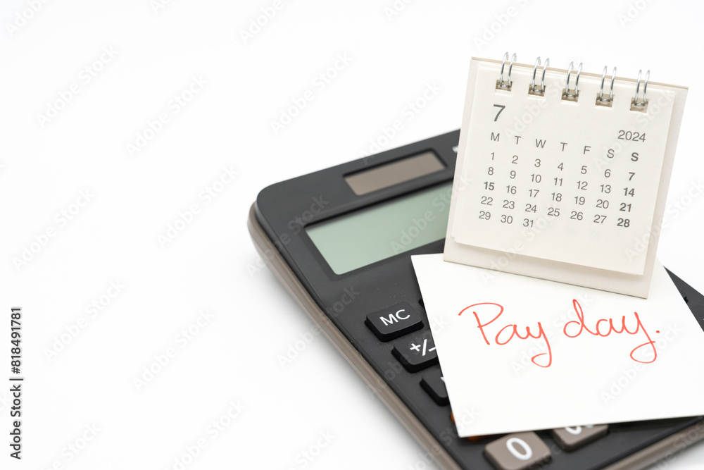 Hand writing text PAY DAY on July 2024 calendar with calculator in ...