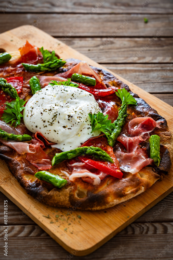 Roman Pinsa with burrata cheese, ripened ham and green asparagus on ...