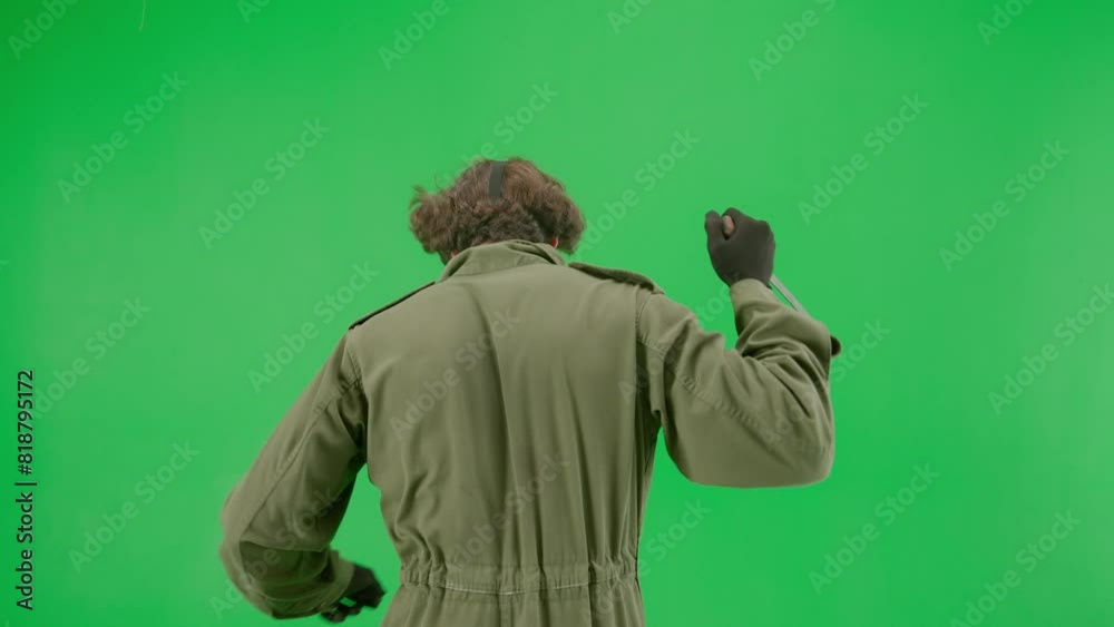 Maniac in jumpsuit running and waving a large sharp knife. An ...