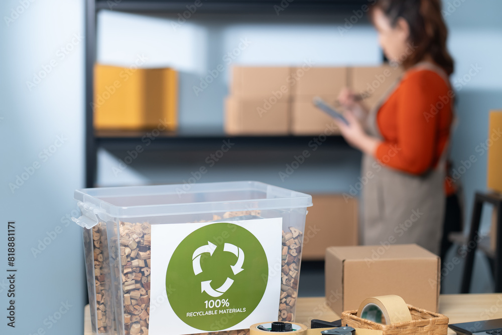 The focus is on a container labeled "100% Recyclable Materials" filled ...