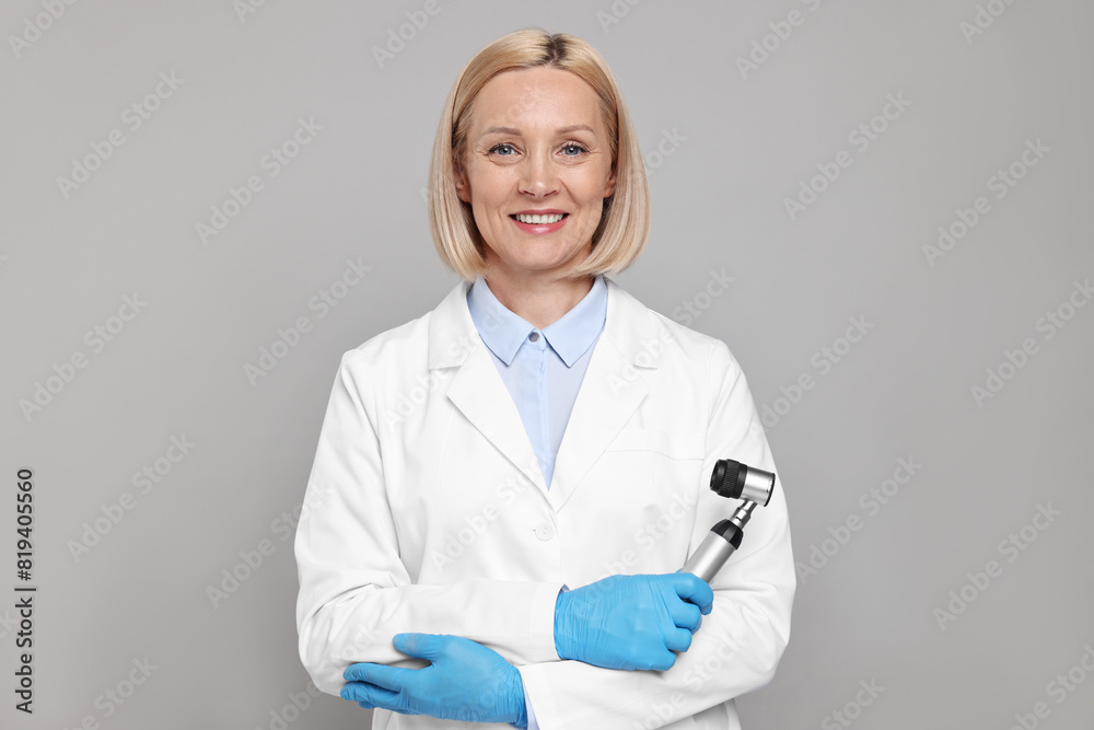 Happy dermatologist with dermatoscope on grey background Stock Photo ...