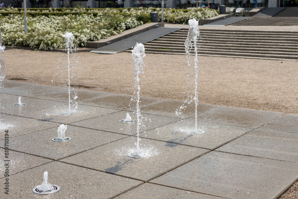 Water droplets spread from the fountain in the air. Splashing water ...