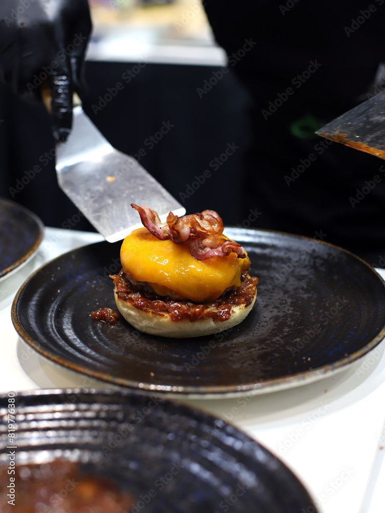 chef sirviendo con una paleta de cocina hamburguesa gourmet de carne y ...