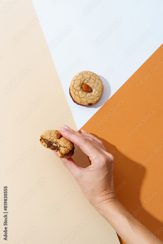 Hand picking a nut biscuit on a two-tone background Stock Photo | Adobe ...