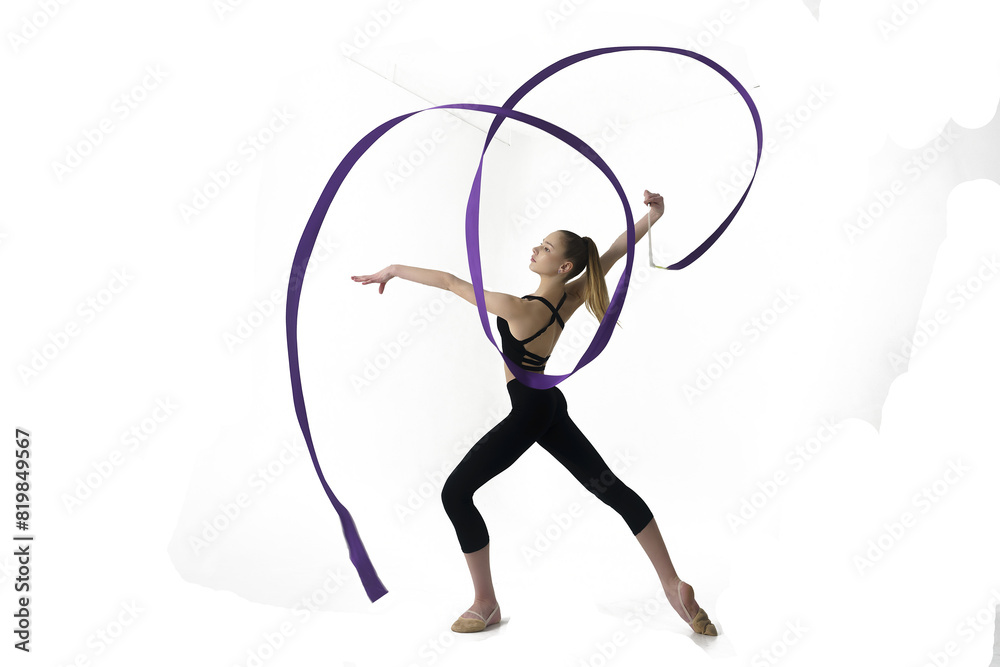 young gymnast in a photo studio shows the elements of exercises with a ...