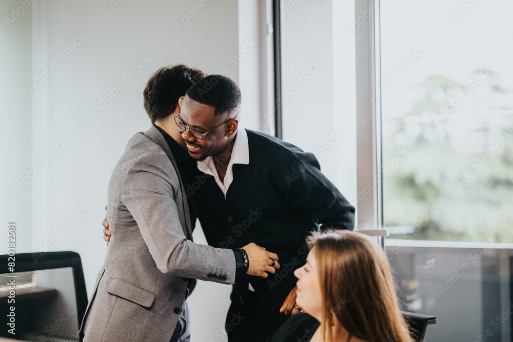 Two male business colleagues embrace in a well-lit office, showing ... Two male business colleagues embrace in a well-lit office, showing ...